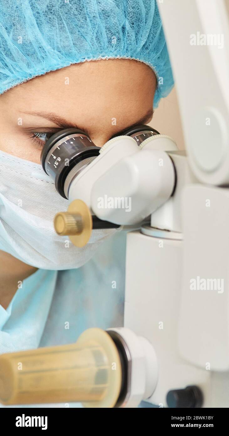 Pretty doctor woman portrait. Ophthalmology laser microscope operation ...