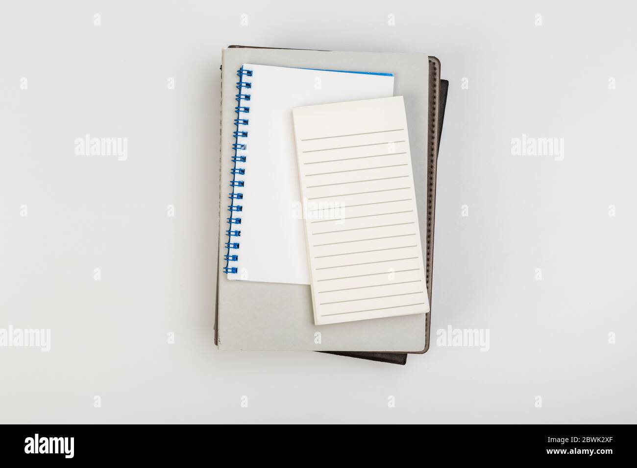 a stack of several spiral school notebooks lies on a white table with a ...