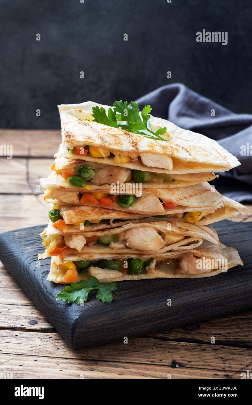 Triangular slices of a Mexican quesadilla with the sauce. The ...