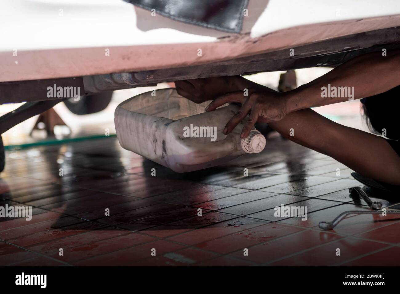 Car mechanic change the car engine oil on the garage Stock Photo - Alamy