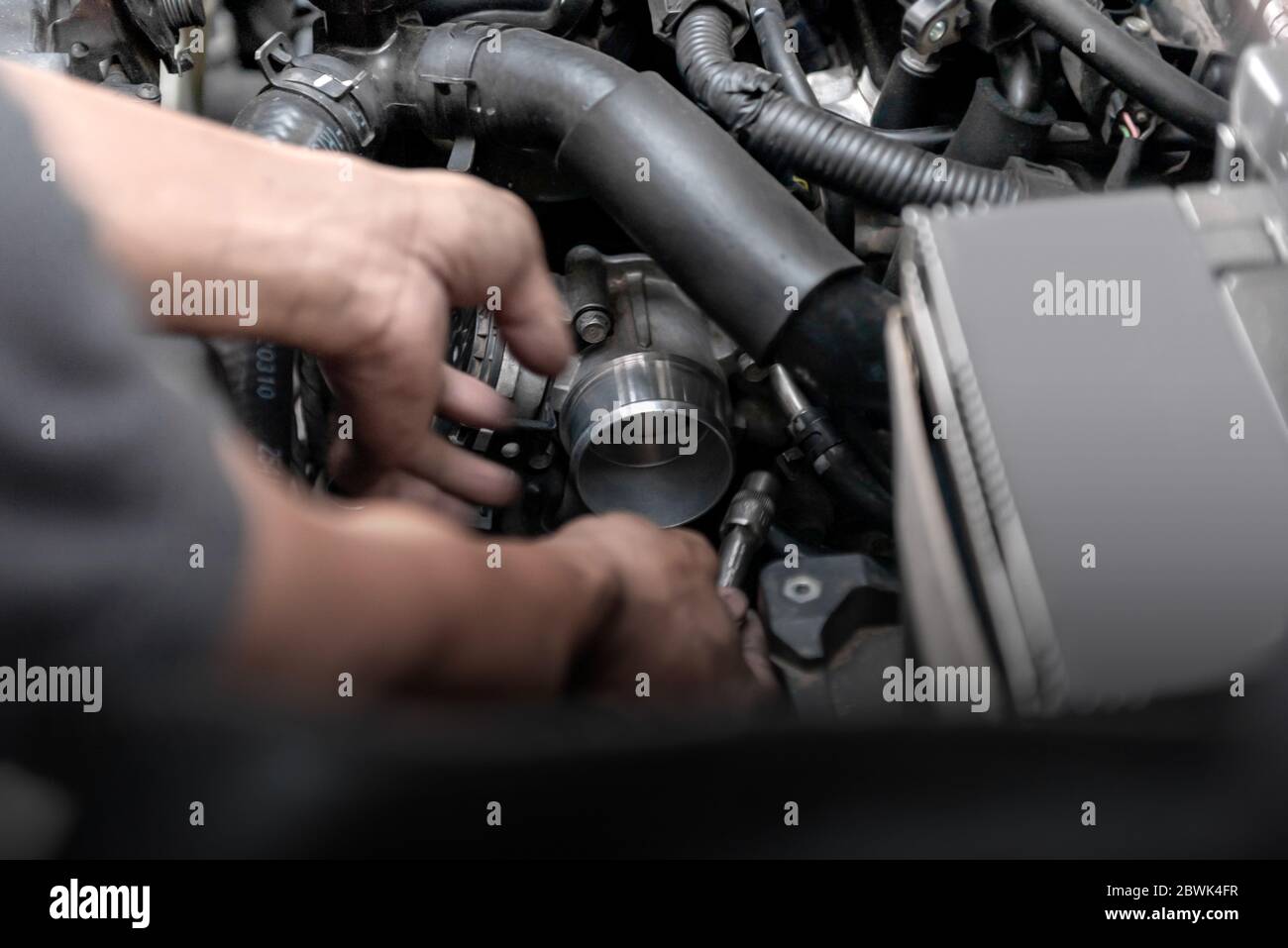 Car mechanic working on engine repair on the garage Stock Photo - Alamy