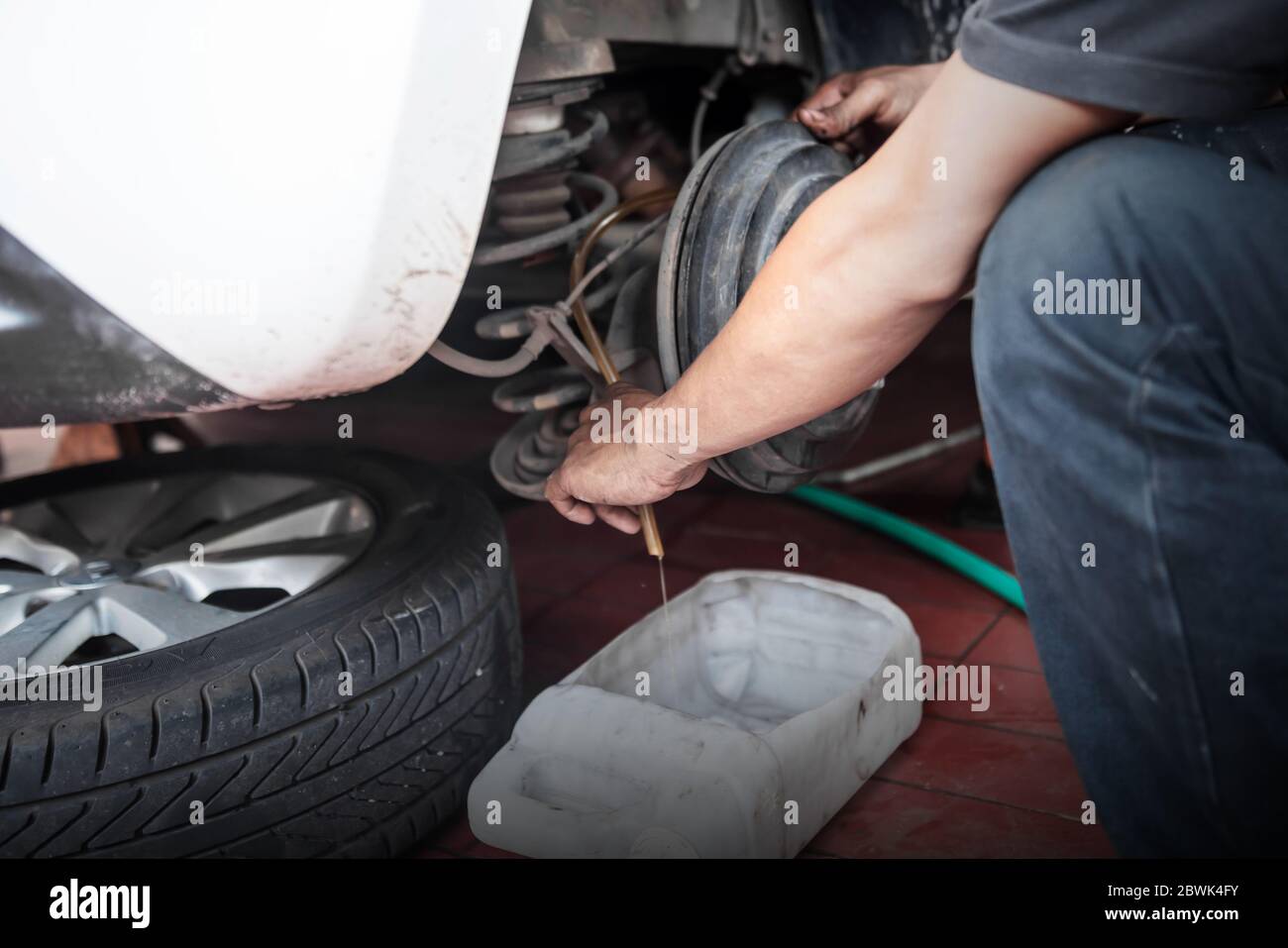 Car mechanic change the car wheel brake oil on the garage Stock Photo ...