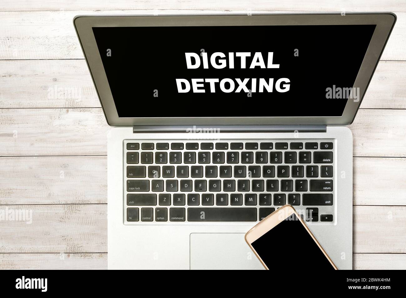 Smartphone and laptop with Digital Detoxing text on wooden table ...