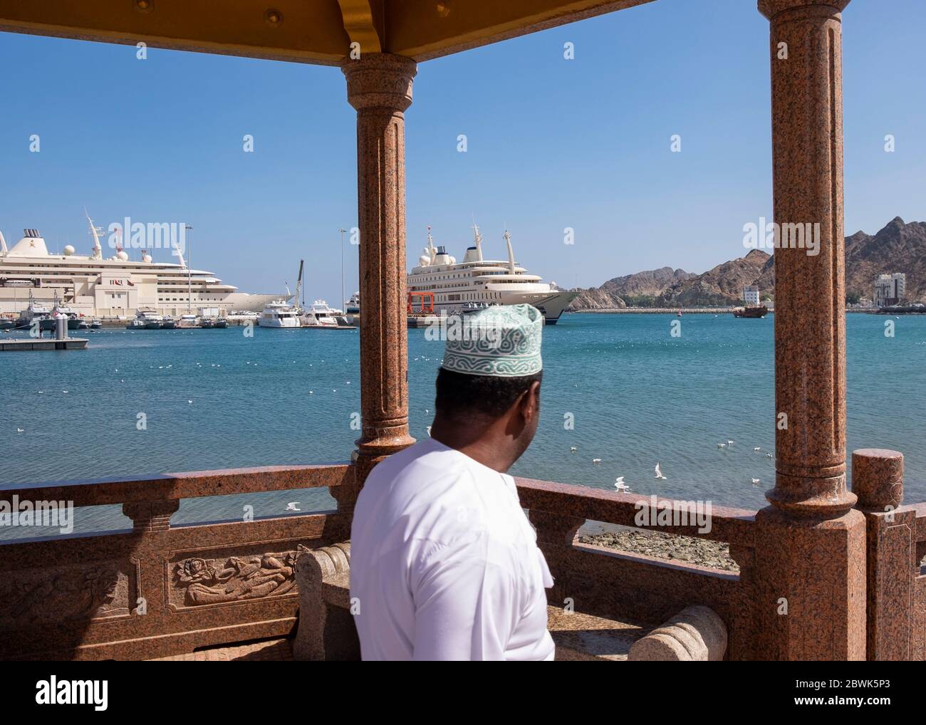 Local Omani man standing in pavilion on Mutrah Corniche, Muscat ...