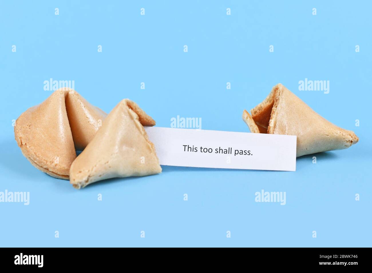 Broken up and whole fortune cookie with motivational text 'This too ...