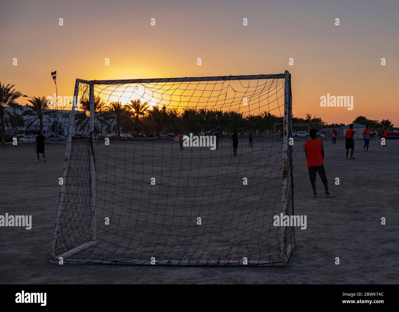 Young men playing football in Al Ghubra suburb at sunset, Muscat ...