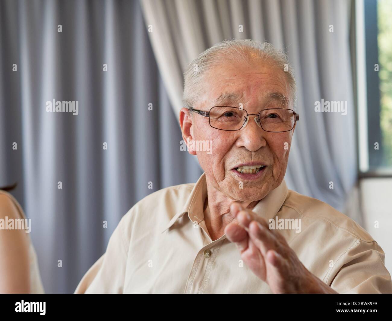 An old man talking animatedly at a family event Stock Photo - Alamy