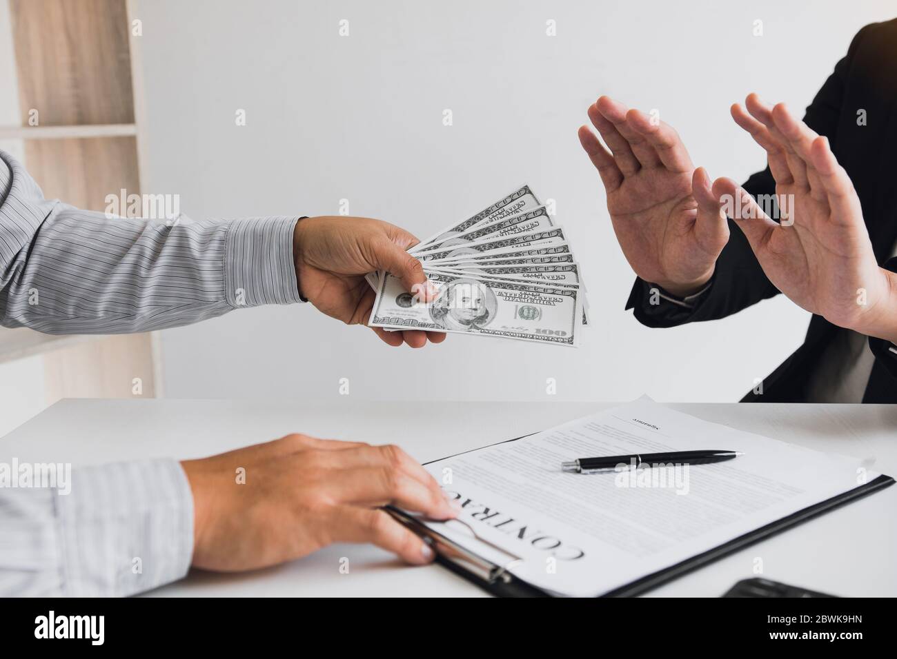 Business person refusing bribe given money by partner with anti bribery ...