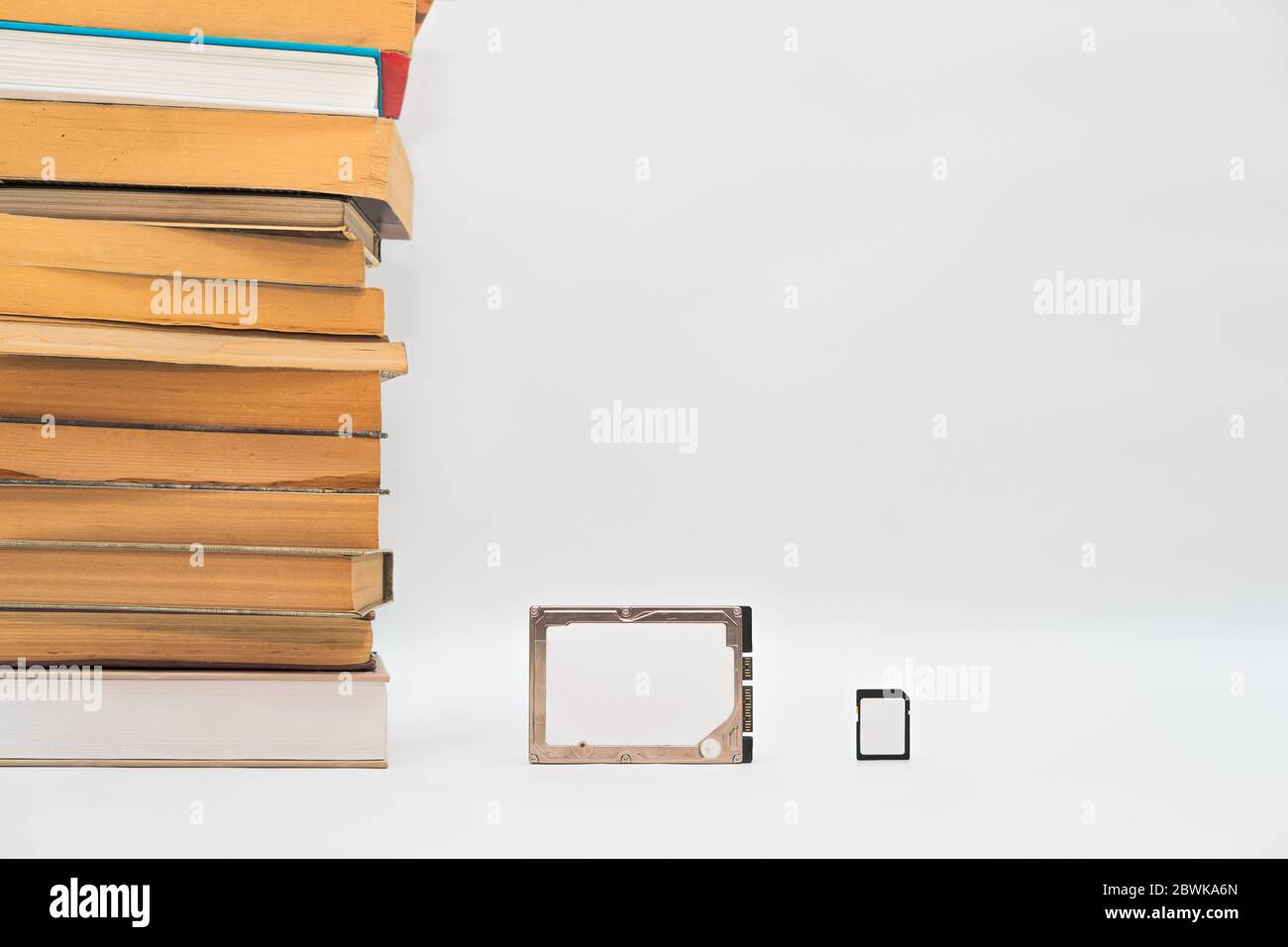 Stack of books, hard disk drive and memory card, improving technology ...