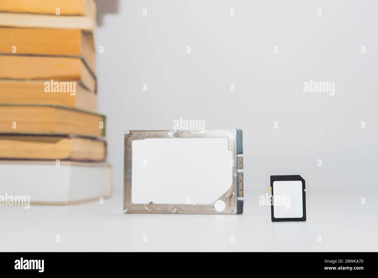 Stack of books, hard disk drive and memory card, improving technology ...