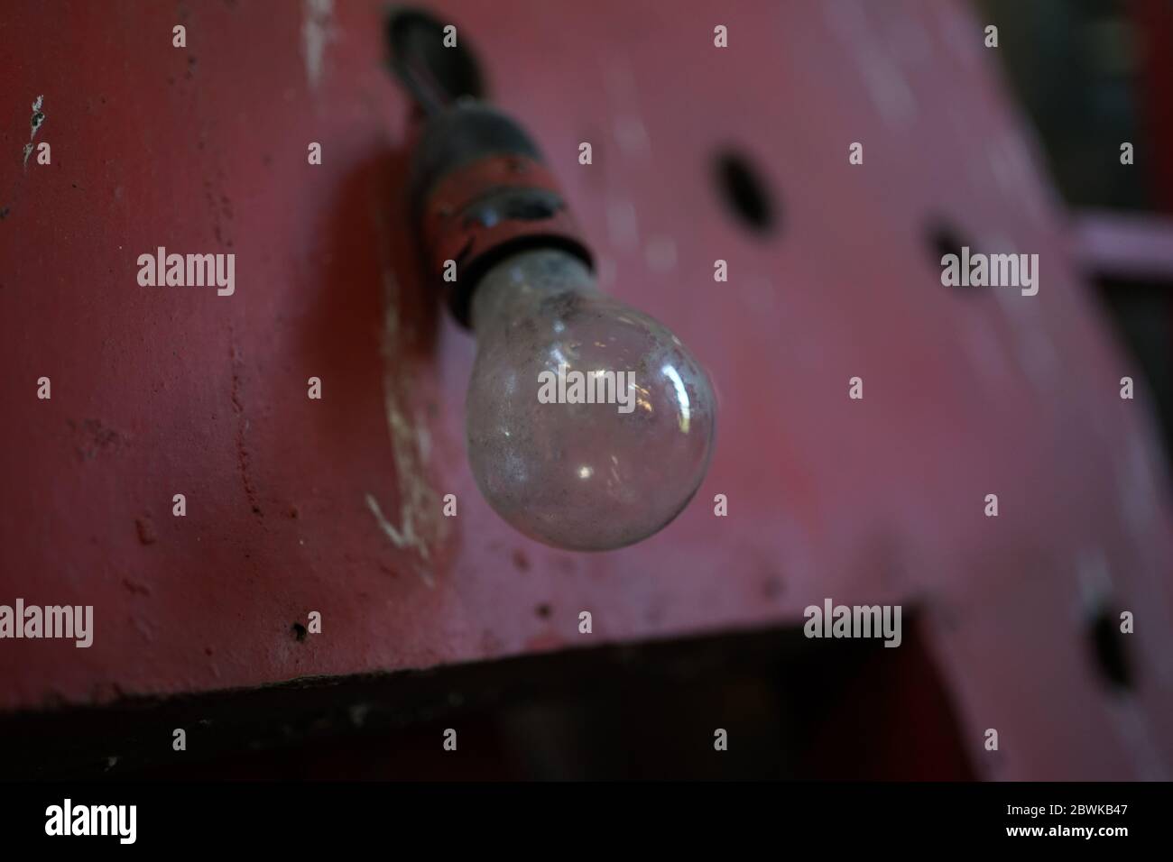 Rusty dusty red antique vintage lightbulb on old advertisement sheet ...