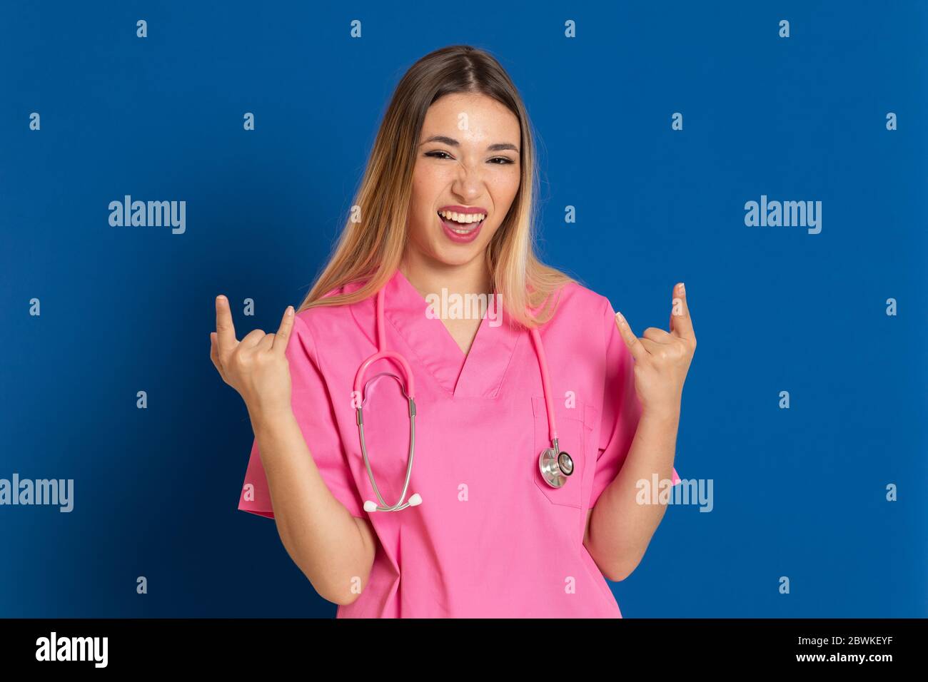 Blonde doctor with pink uniform on a blue background Stock Photo - Alamy