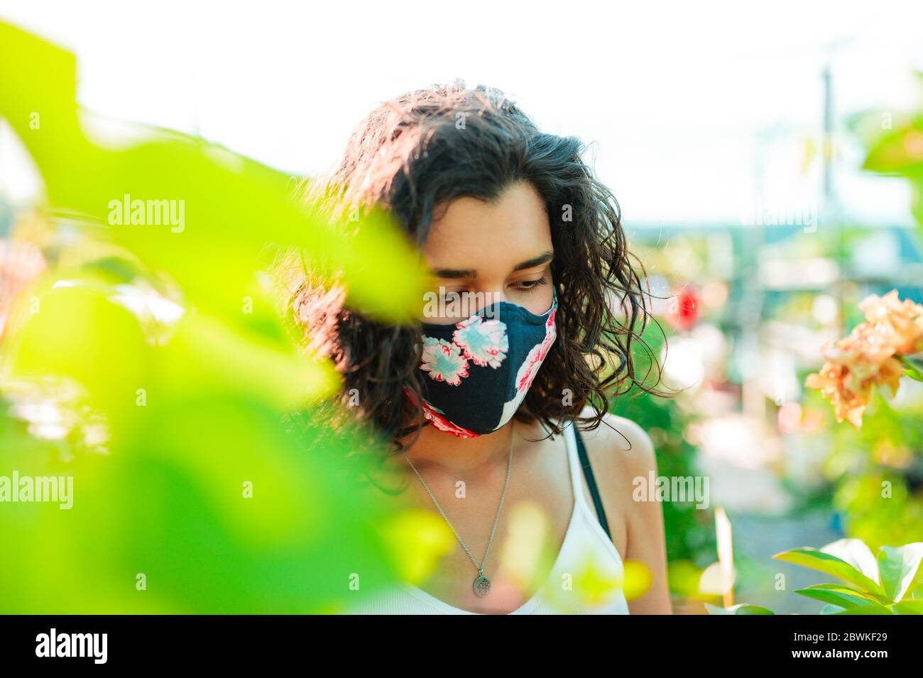 Woman with face mask gardening in greenhouse covid-19 Stock Photo - Alamy