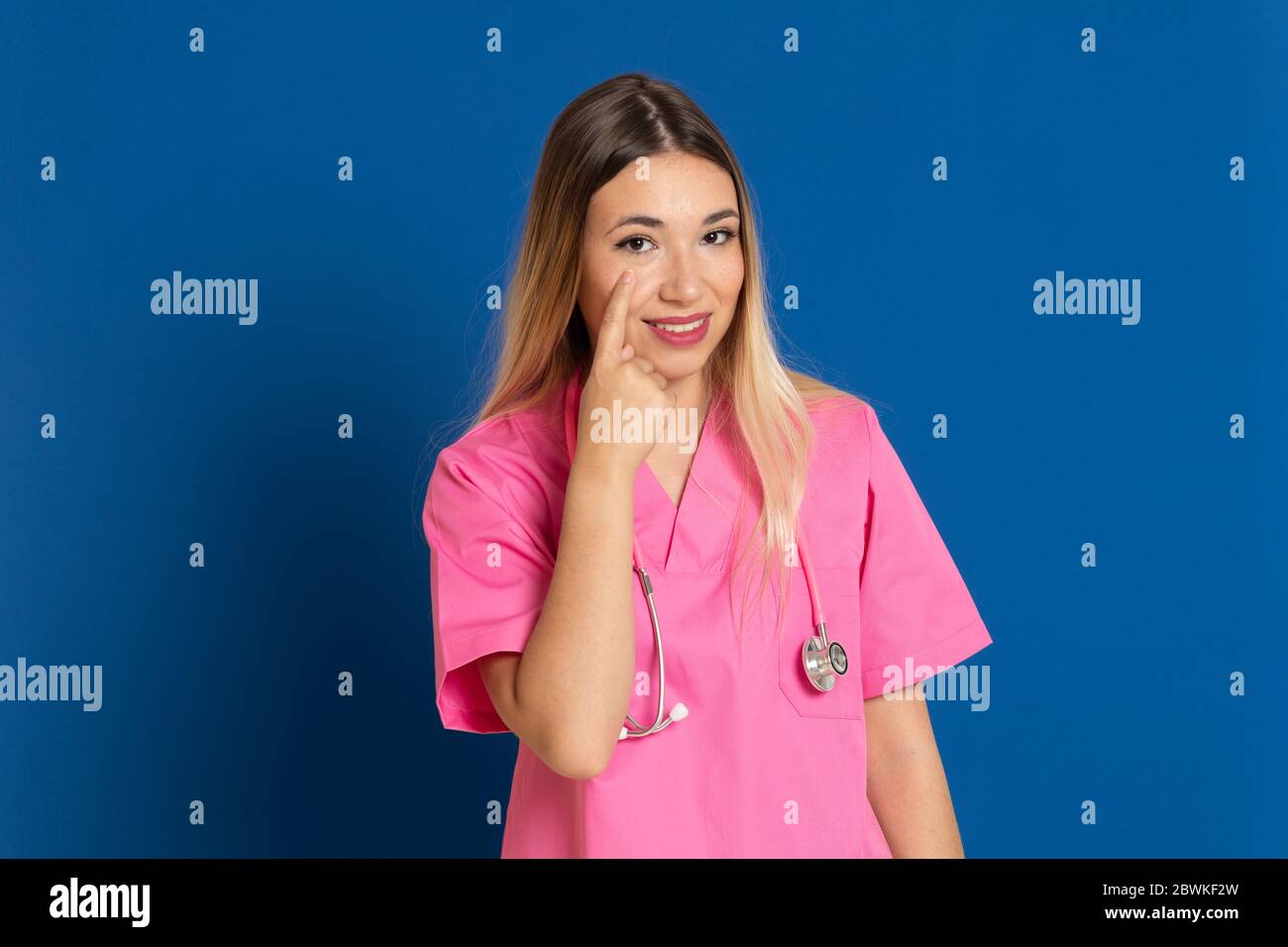 Blonde doctor with pink uniform on a blue background Stock Photo - Alamy