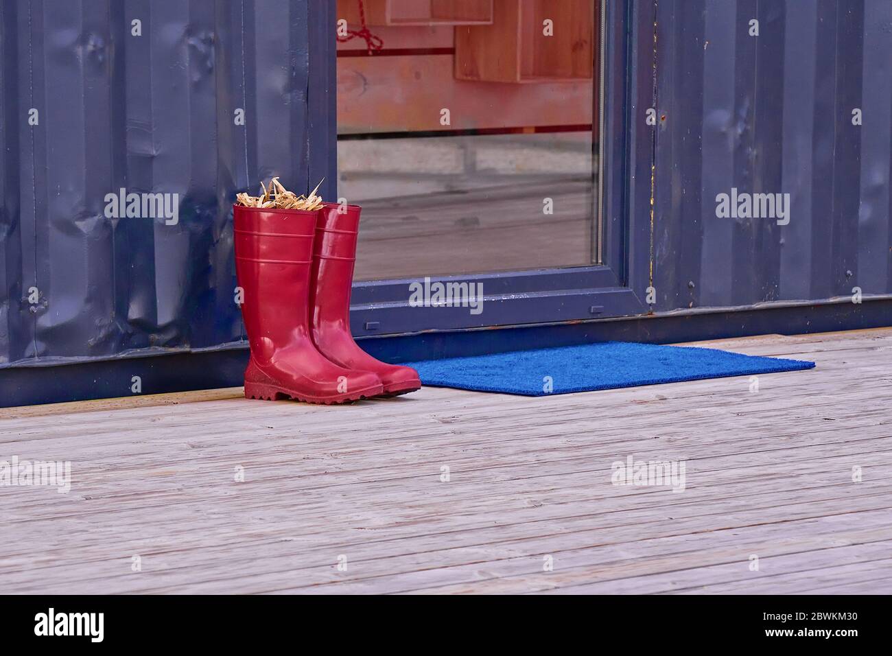 Red rubber boots standing at the entrance to house as design elements ...