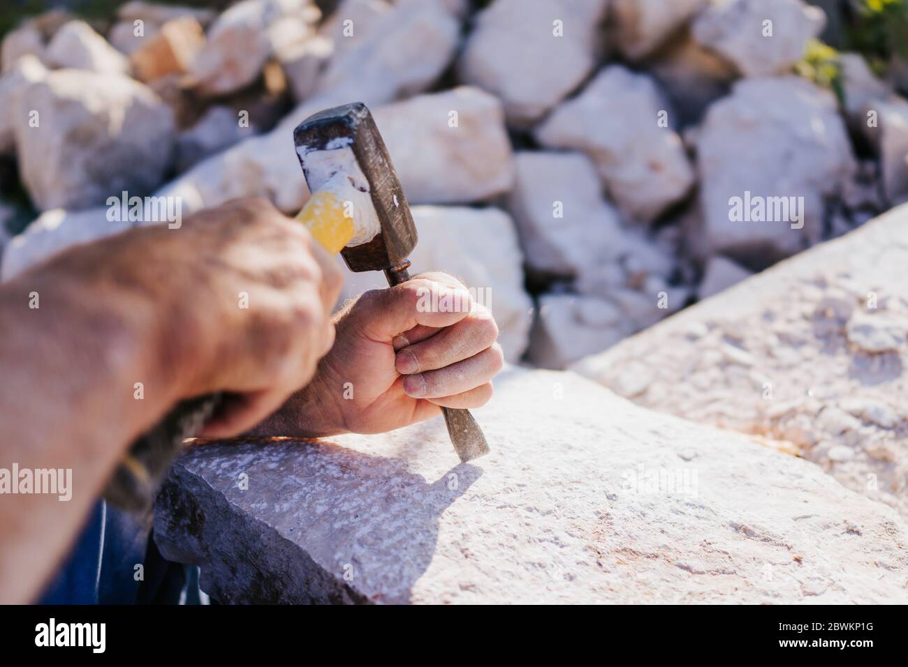 Stone carver working with hammer and chisel Stock Photo - Alamy