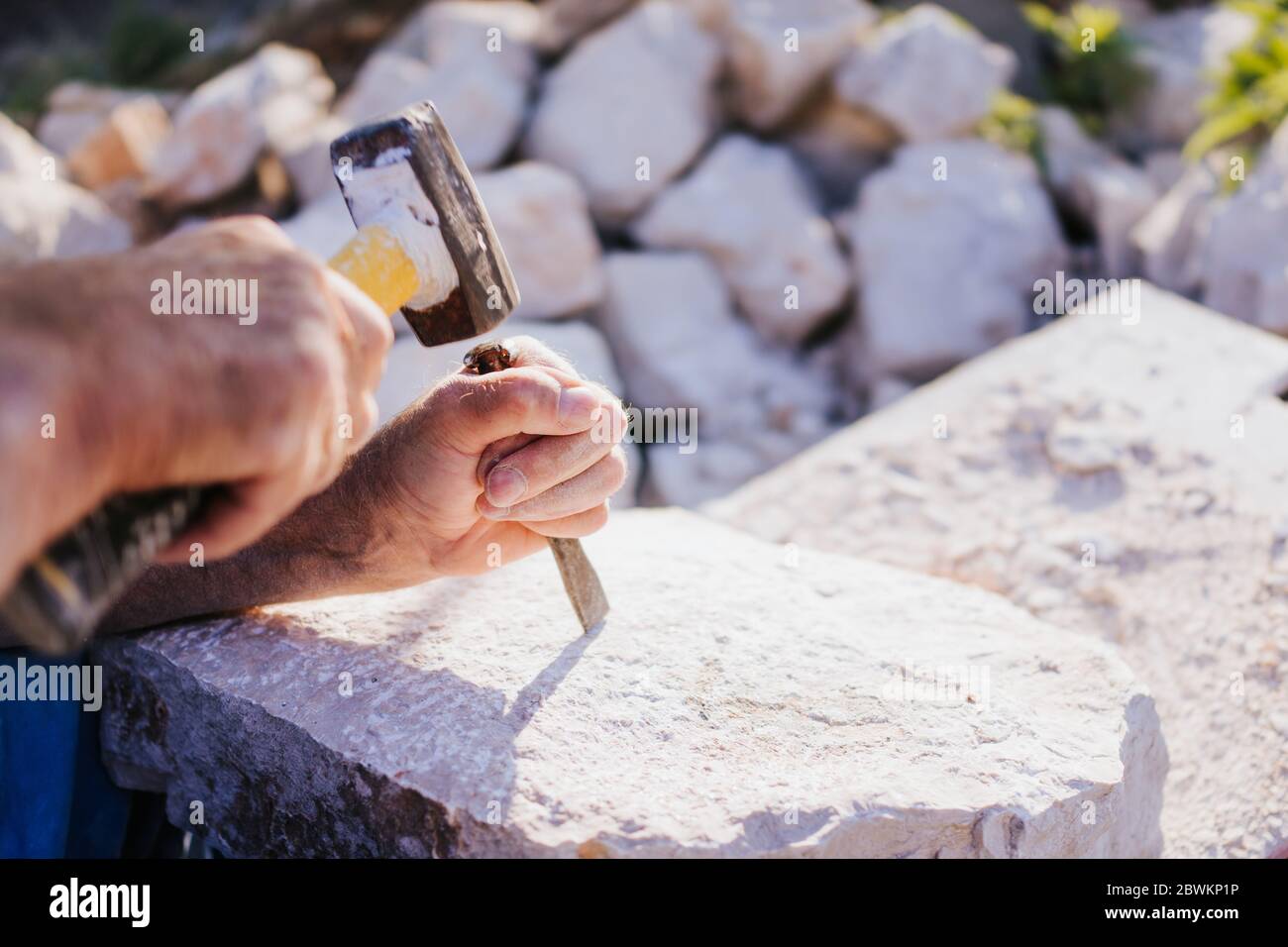Stone carver working with hammer and chisel Stock Photo - Alamy