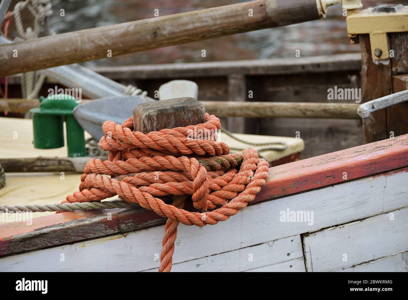 thick orange rope on the rail of an old wooden fishing boat, selected ...