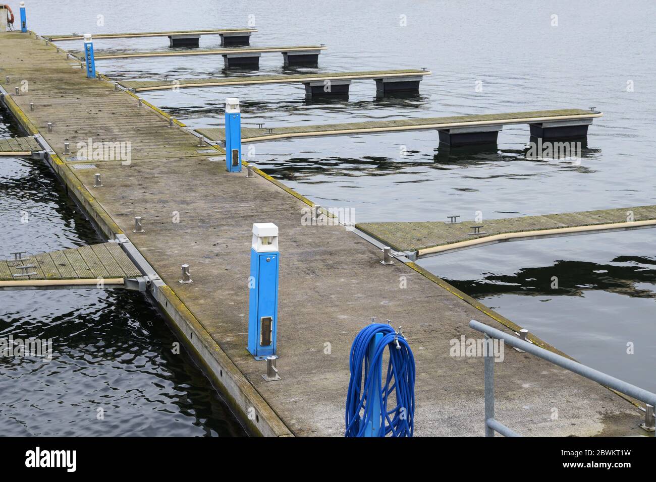 Empty jetties with blue electric boxes and hose, a yacht marina out of ...