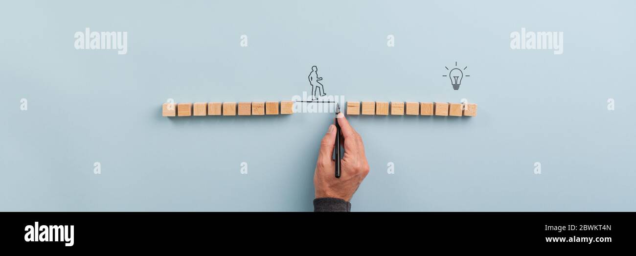 Male hand drawing a connecting line between two sets of wooden blocks ...