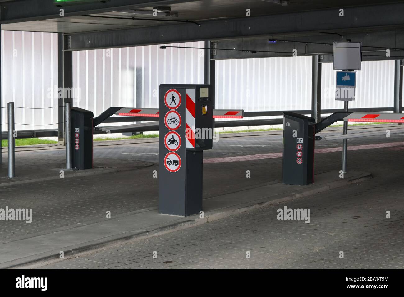 Entrance to a multi-storey car park or parking garage with barriers and ...