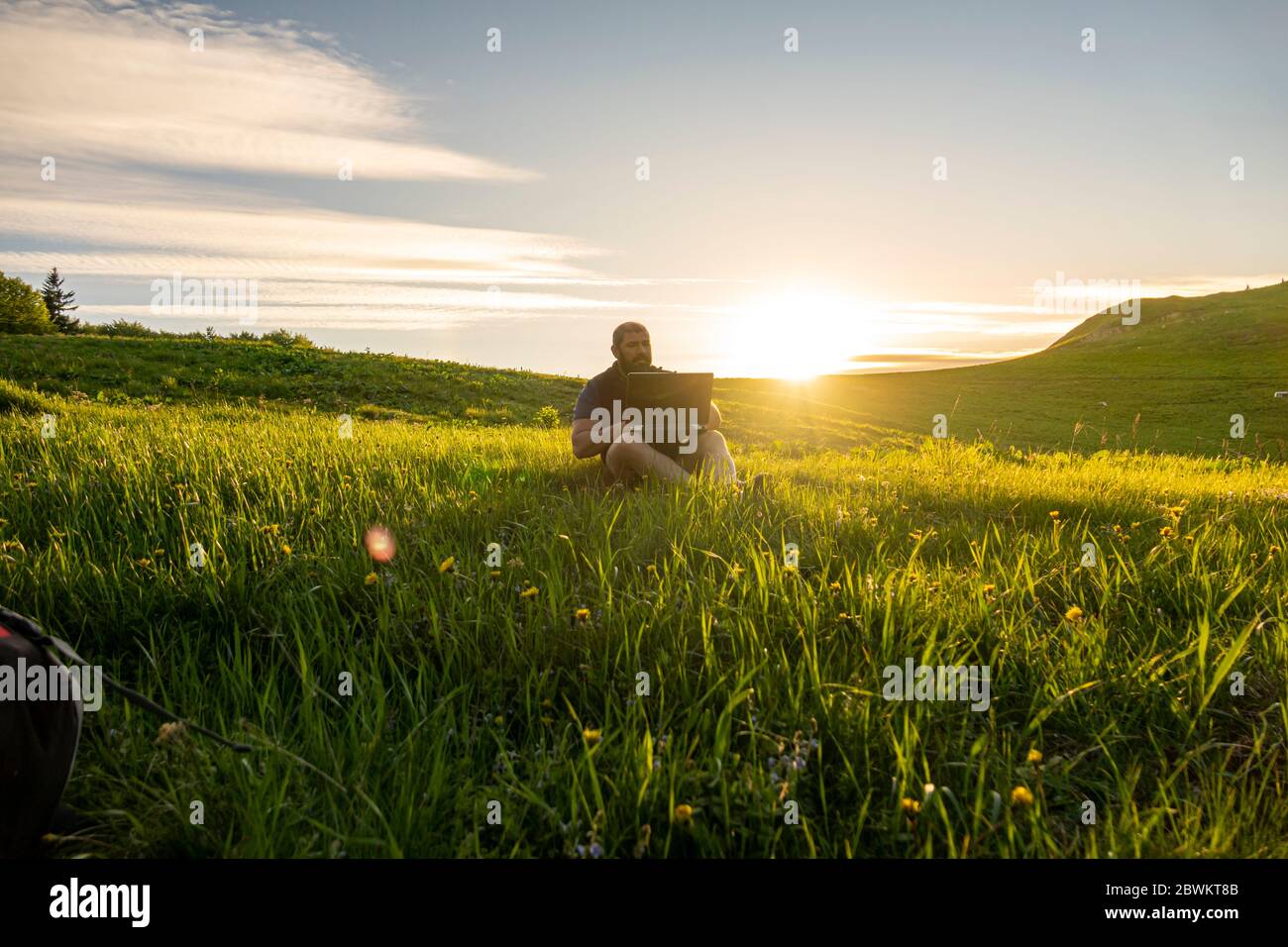 man working outdoors with laptop. Green spring mountain landscape Stock ...