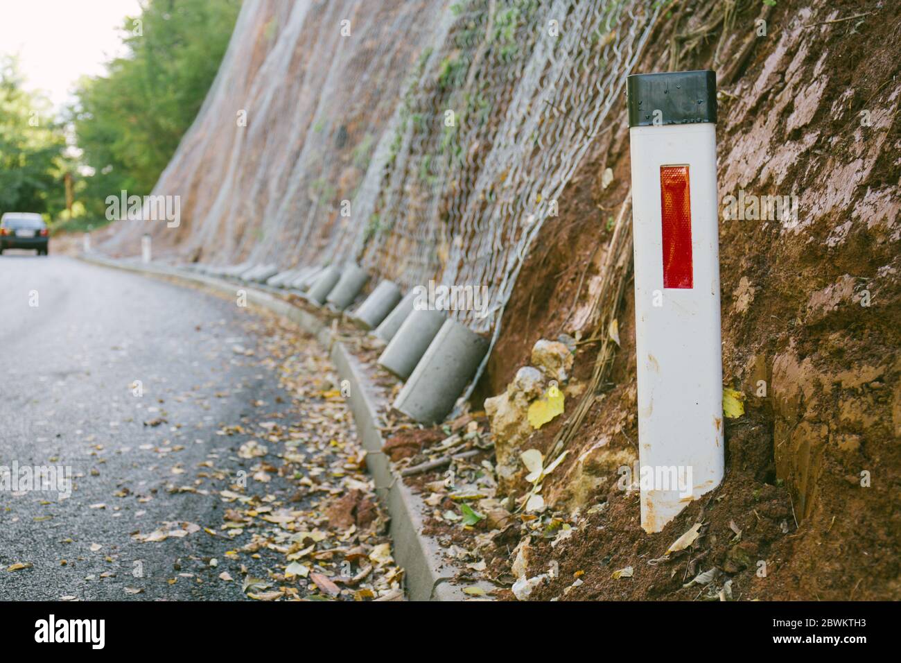red-white barrier erected at the end of the road, mountain, slope, net ...