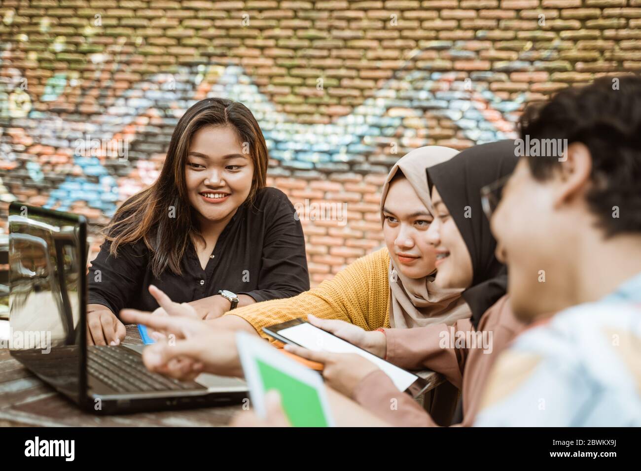Asian group of students learning together using book and laptop Stock ...