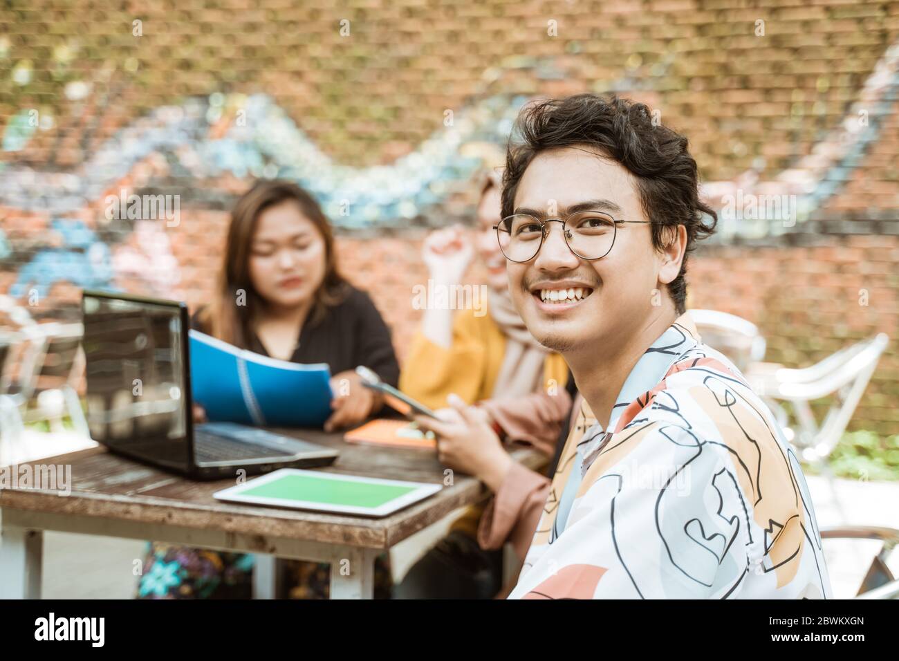 Groups of teenagers learn together to work on college assignments in ...
