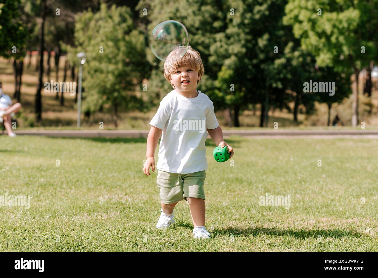 Funny little boy catching soap bubbles in the summer on nature little ...