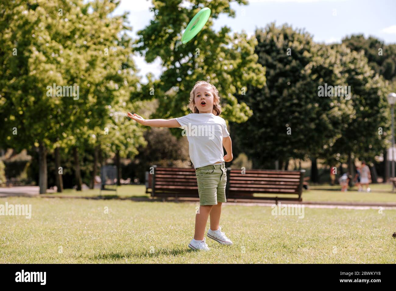 blond boy plays frisbee in the park on a sunny summer day. play abroad ...