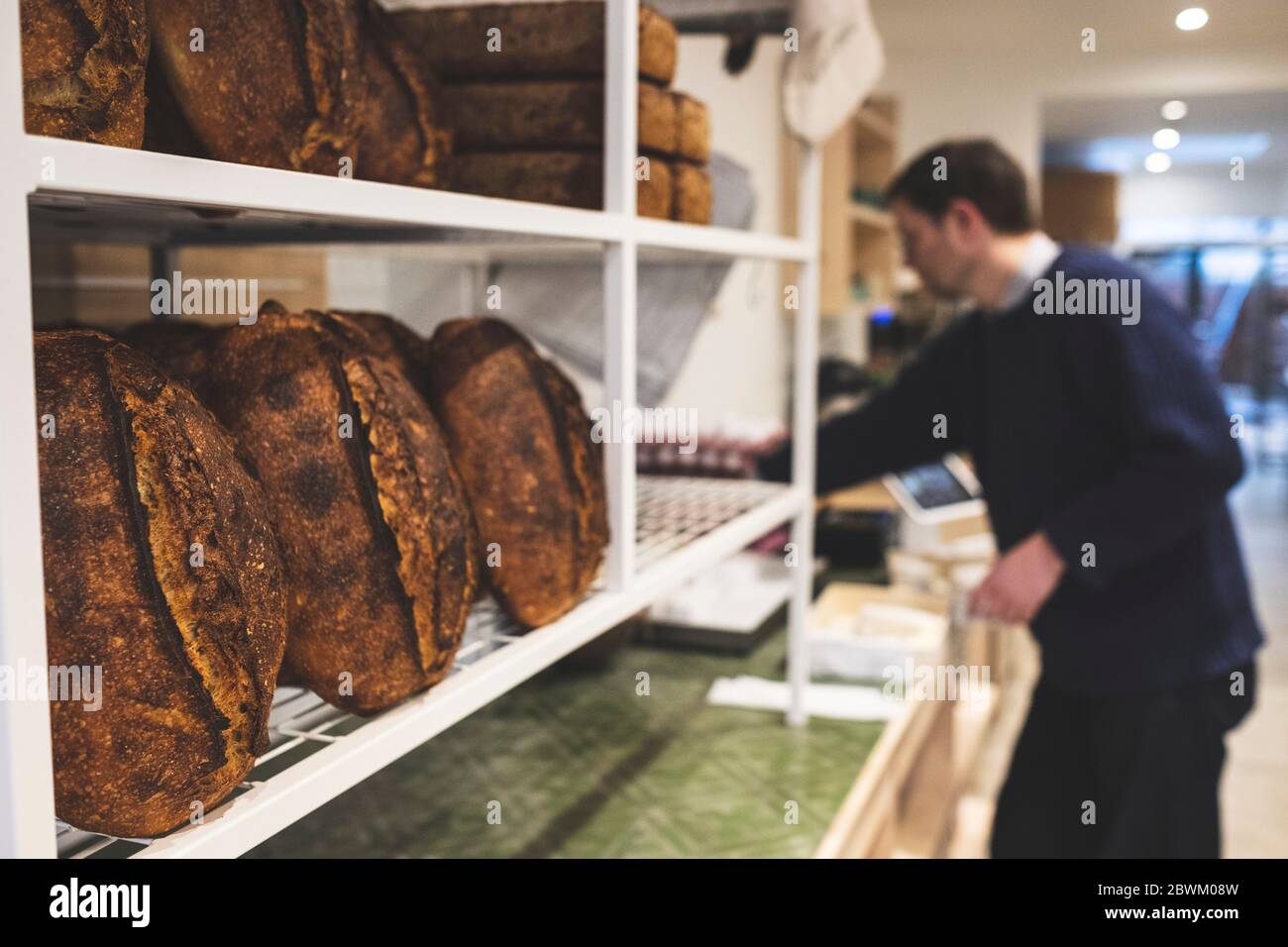 Artisan bakery making special sourdough bread, racks of cooked loaves ...