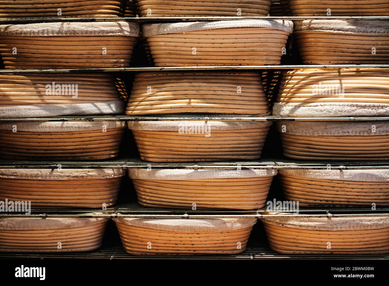 Artisan bakery making special sourdough bread, proving baskets on racks ...