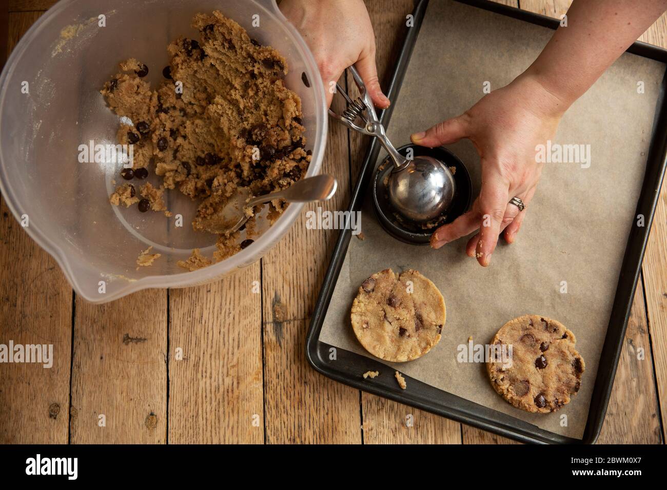 High angle close up of person standing at wooden table, baking ...