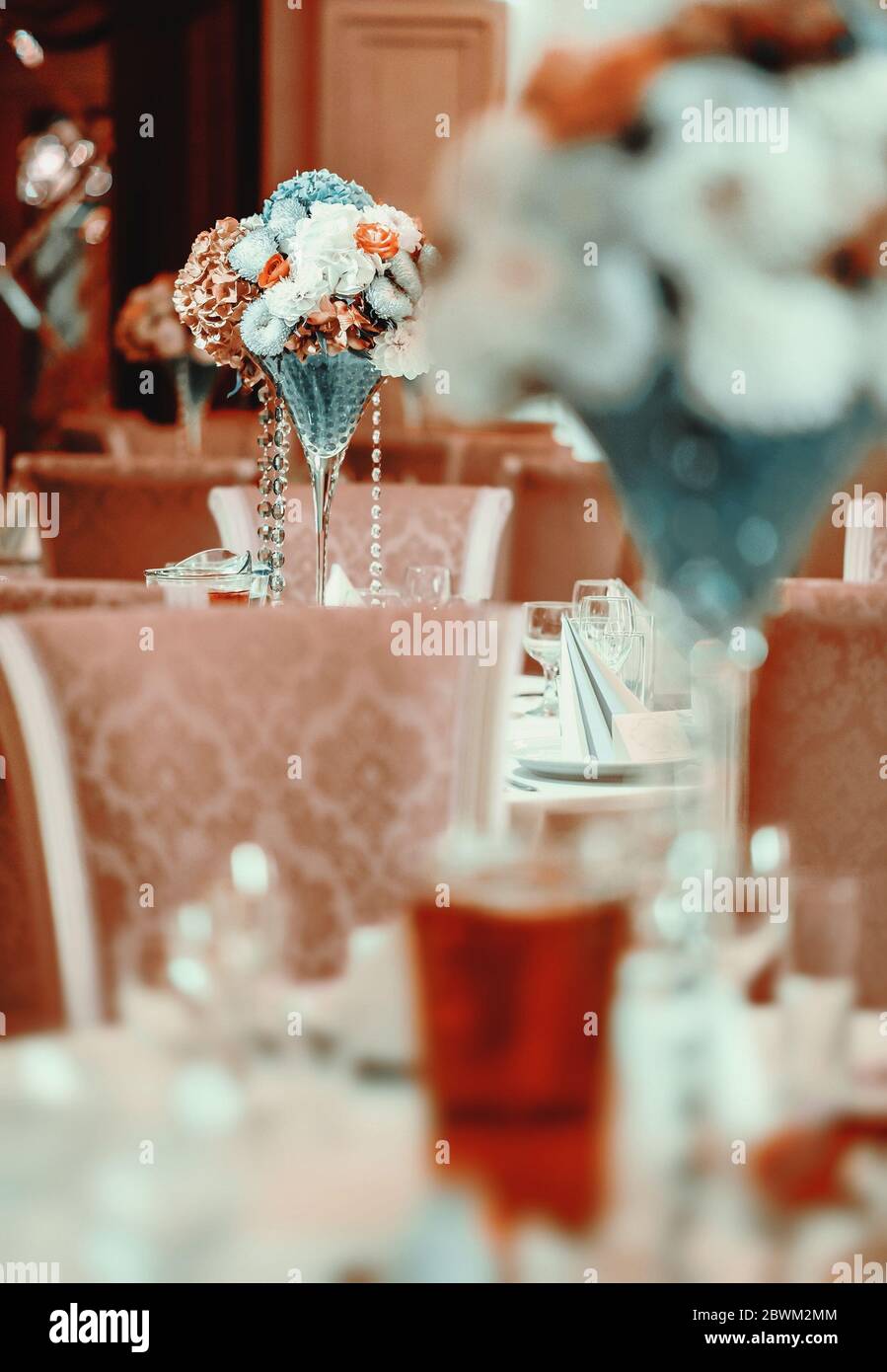 Beautifully decorated of luxury wedding banquet at restaurant. Bouquet of flowers on served ...