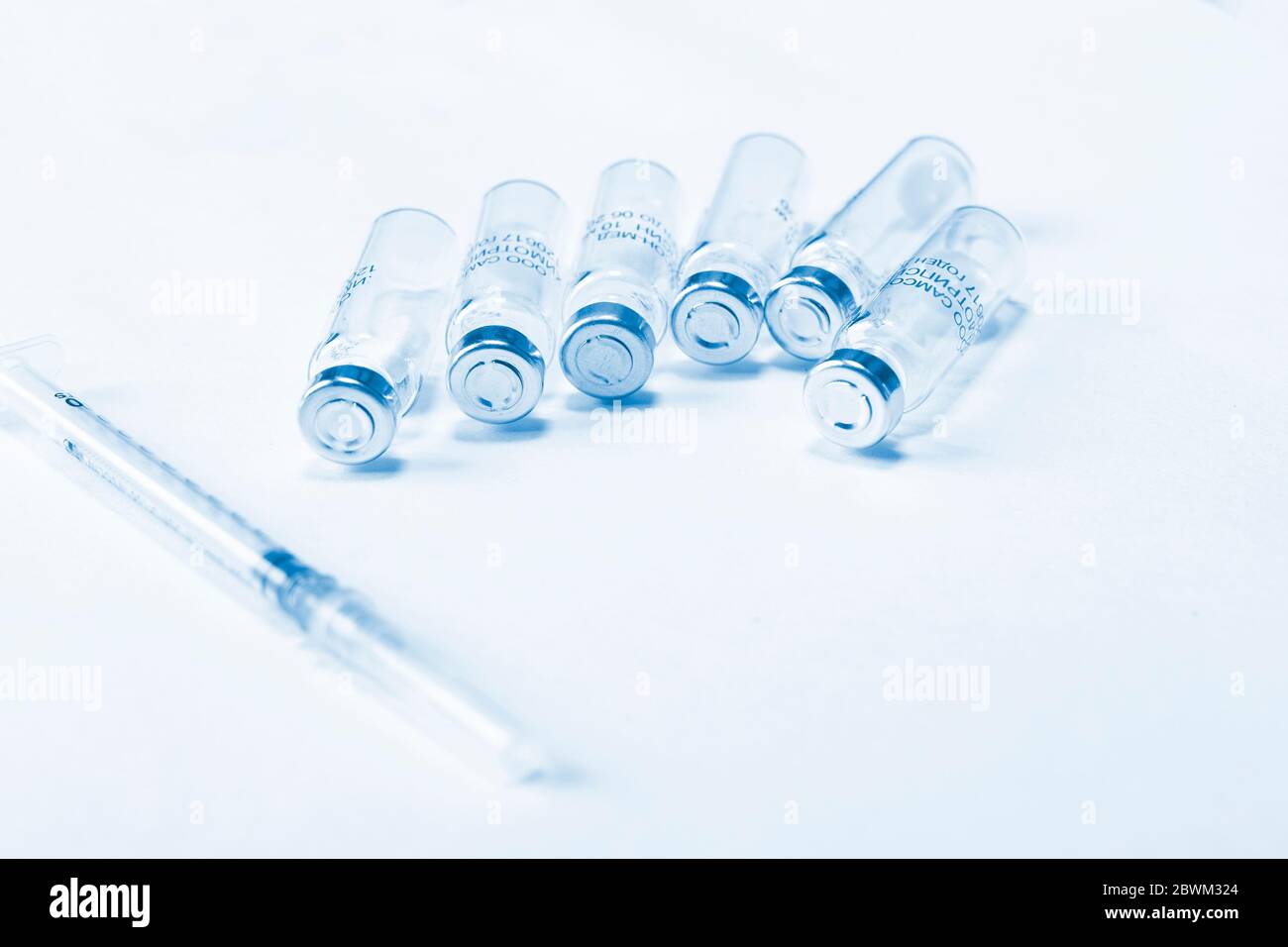 medical glass vials with solution for injection and syringe on white ...