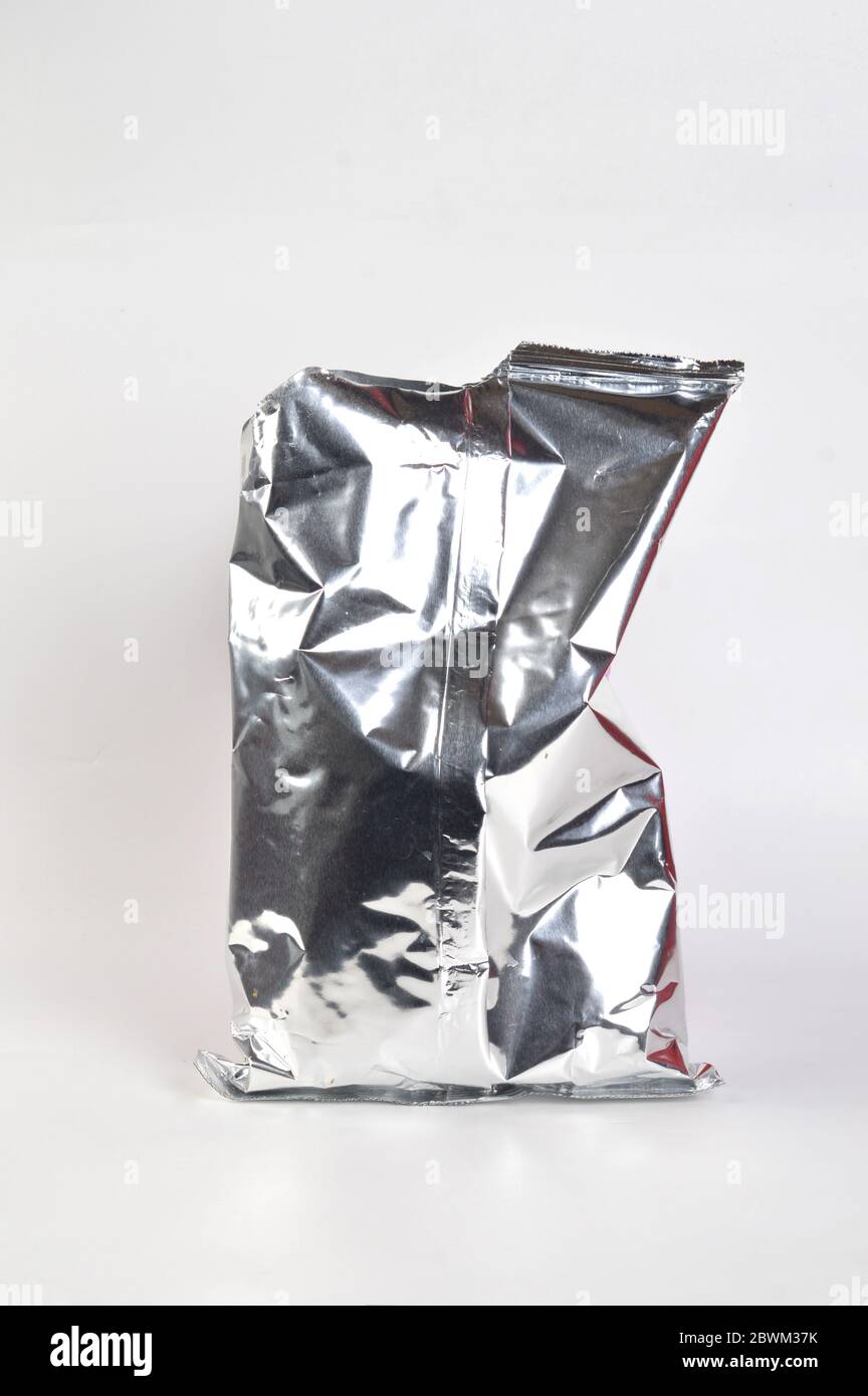 silver aluminum pouch with a tear in the corner on white background ...
