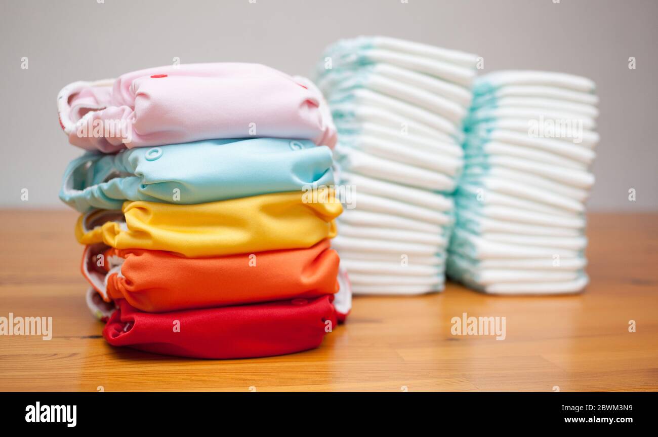 Stacks of disposable diapers and modern cloth diapers together Stock ...