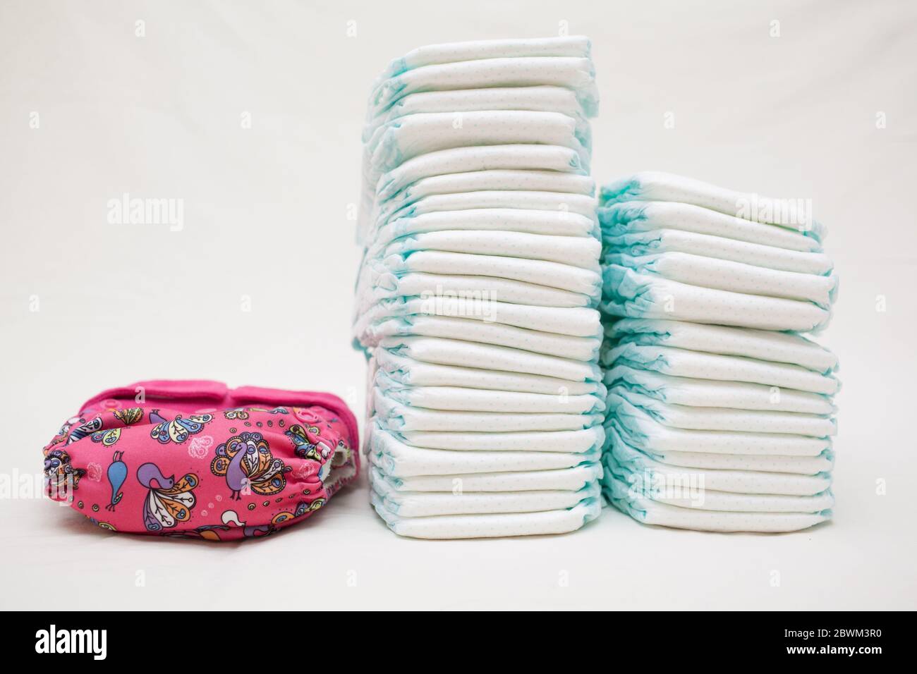 Stacks of disposable diapers and modern cloth diapers together Stock ...