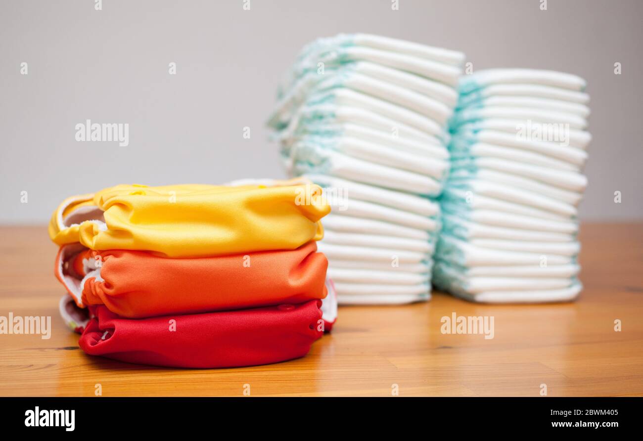 Stacks of disposable diapers and modern cloth diapers together Stock ...