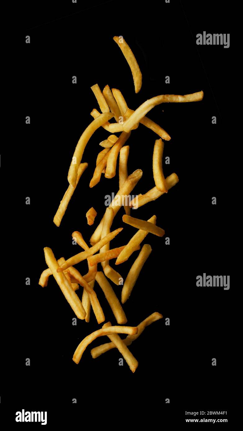 French fries flying in the air isolated on black background, Stop ...