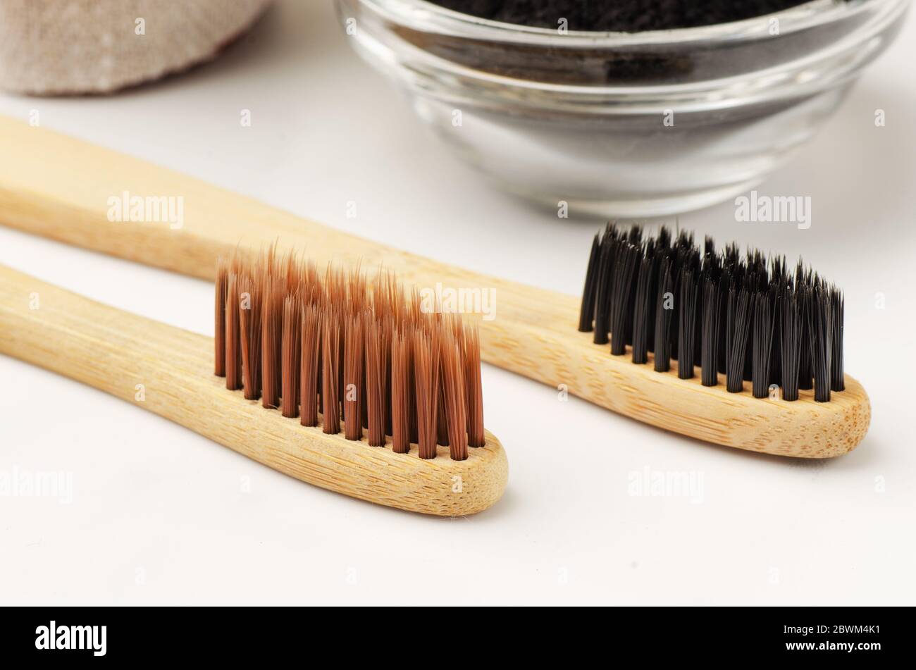 Bamboo toothbrush with black charcoal toothpaste powder on a white ...