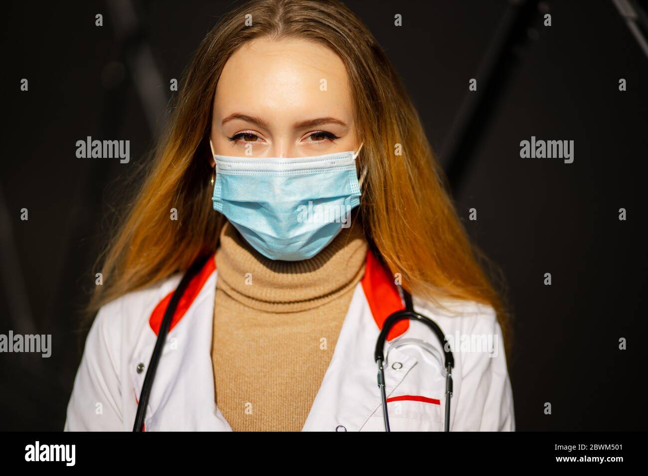 Close face view of female doctor or nurse in surgical mask and white ...
