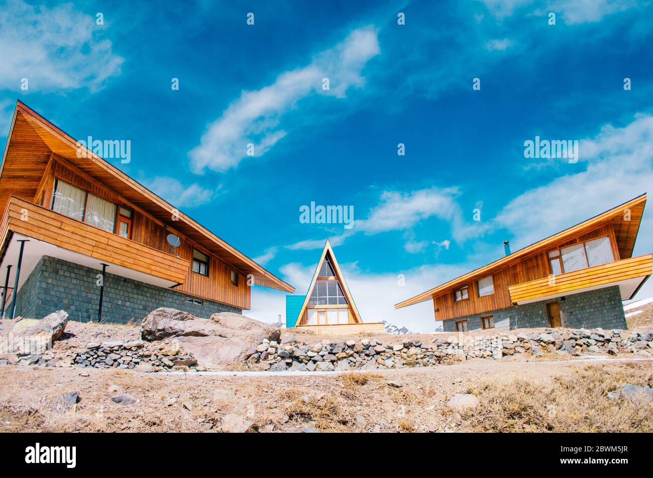 A small triangle shaped bungalow next to two other wood cabins in the ...