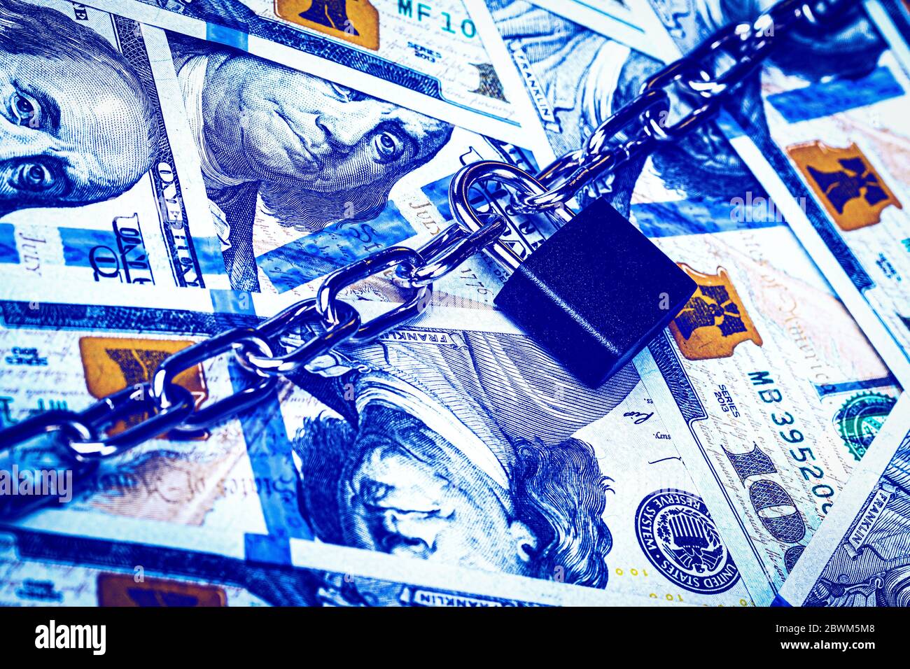 Dollar bills, black lock and metal chain. Money lock or security ...