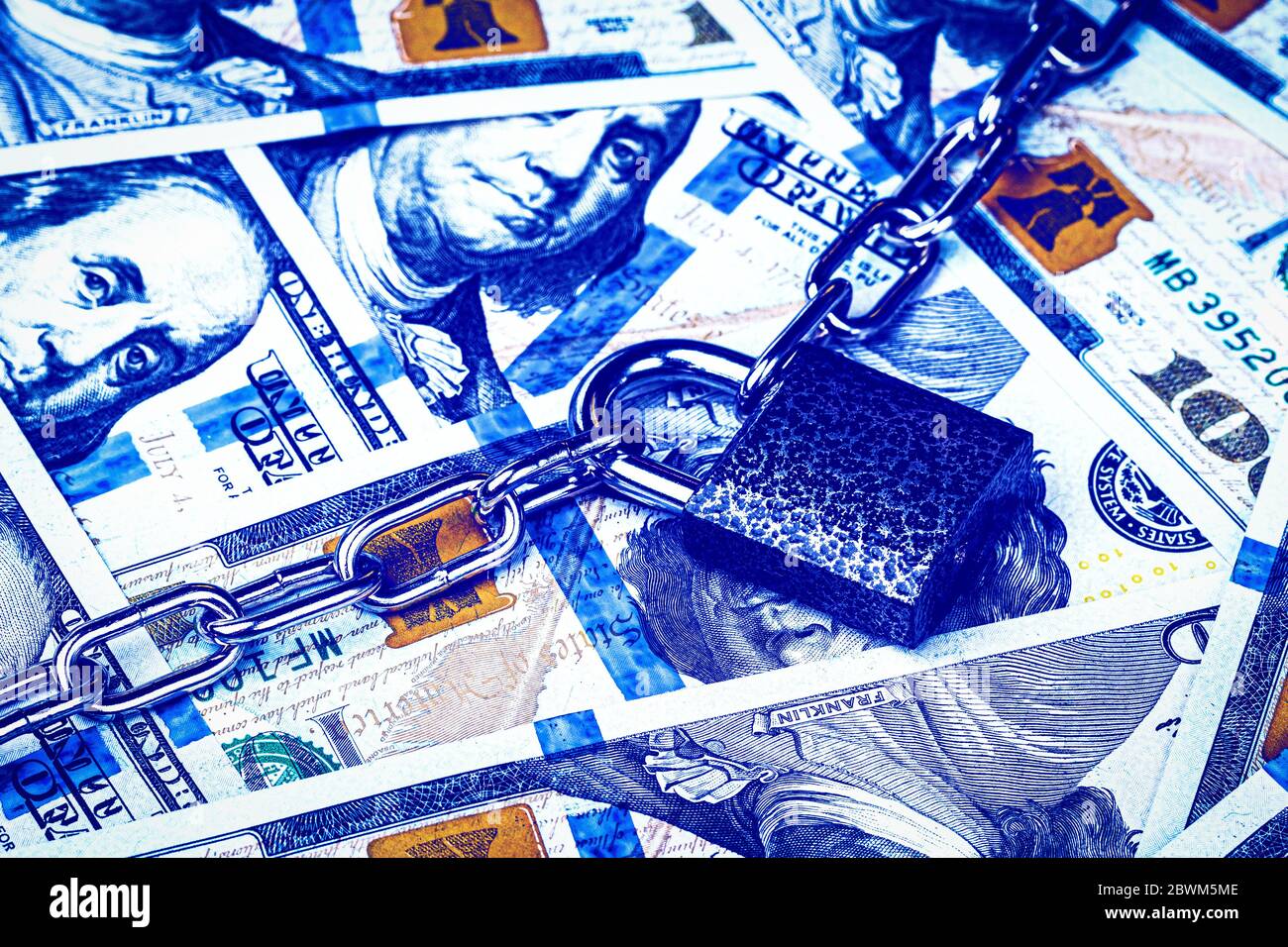 Dollar bills, black lock and metal chain. Money lock or security ...
