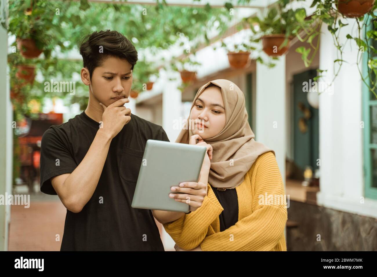 students male and hijab girl worries when looking to the screen of the ...