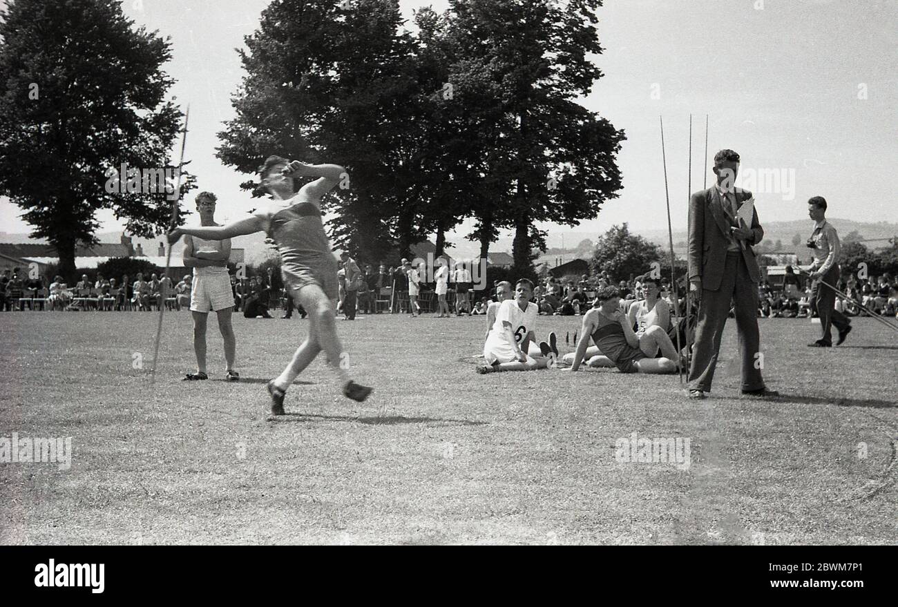 1950s, historical, summertime and outside in a sports field at a school ...