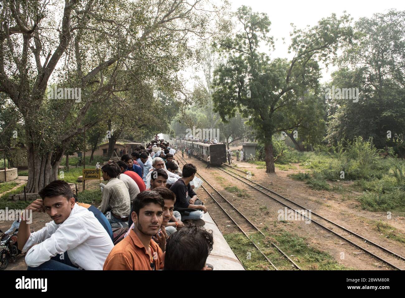 Men on top of overcrowded train passing through countryside in Madhya ...