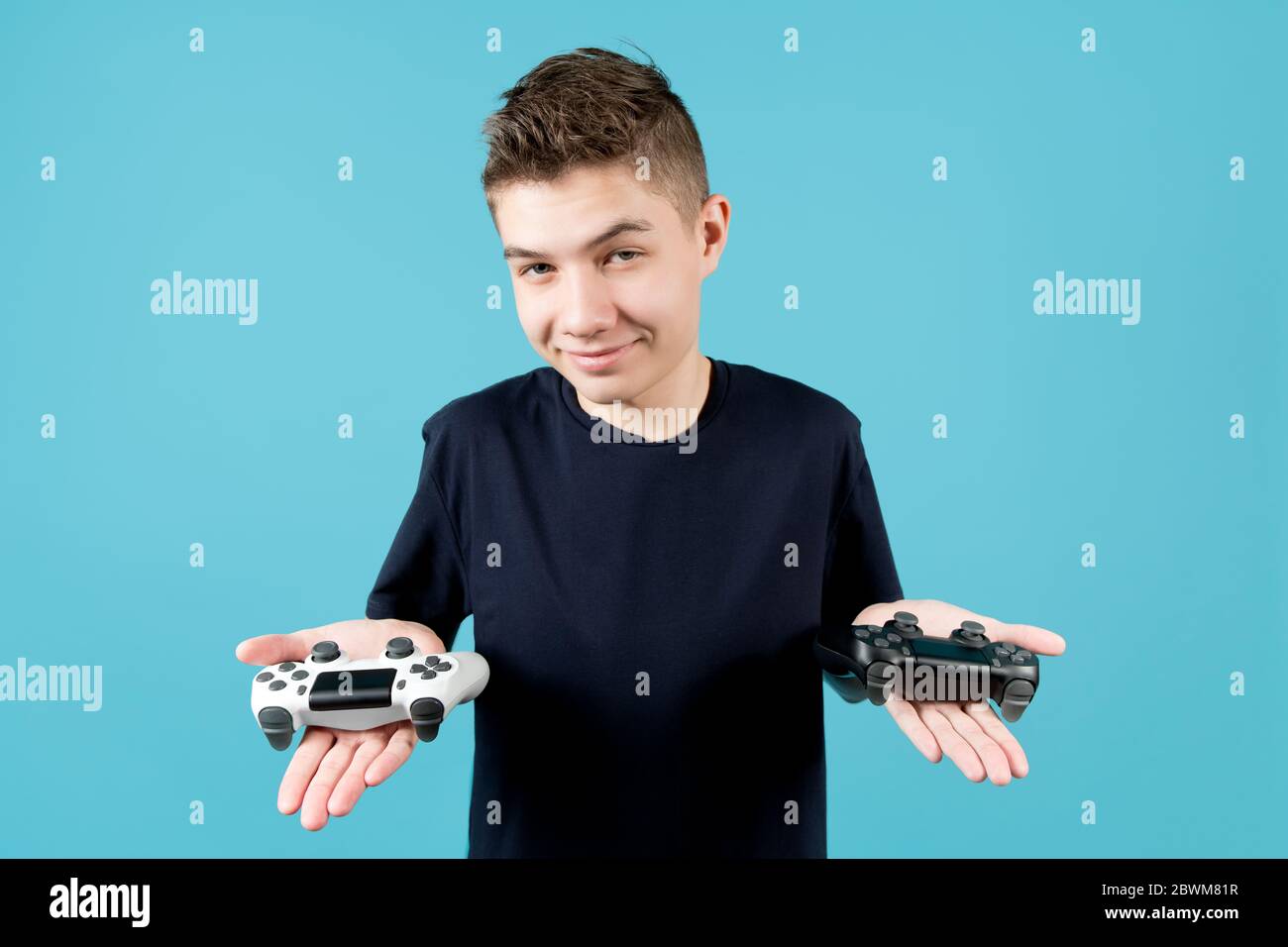 The young man smiles slyly, holding the joysticks in his hands from the ...